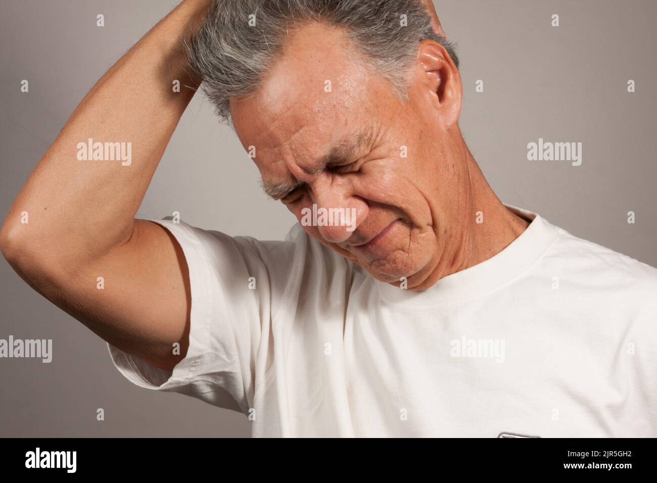 Mature Man 60plus doing back of the neck stretches for back and neck ...