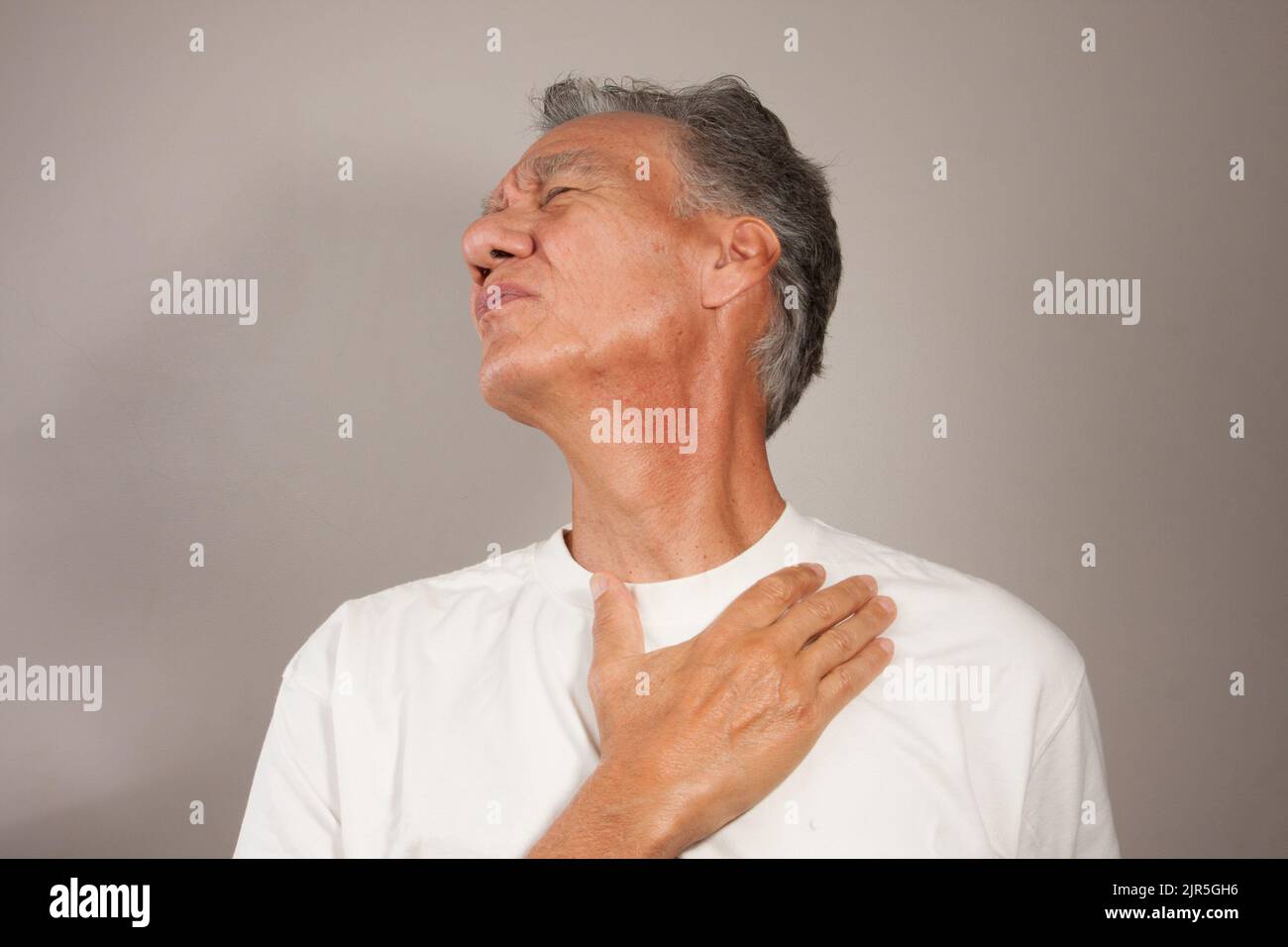 Mature Man 60plus doing back of the neck stretches for back and neck ...