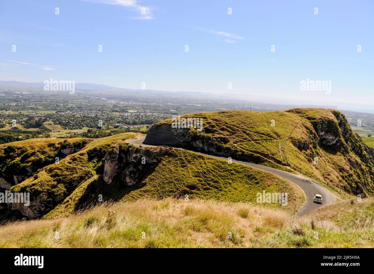 A car makes its way down a single track mountain road with lay-bys on ...