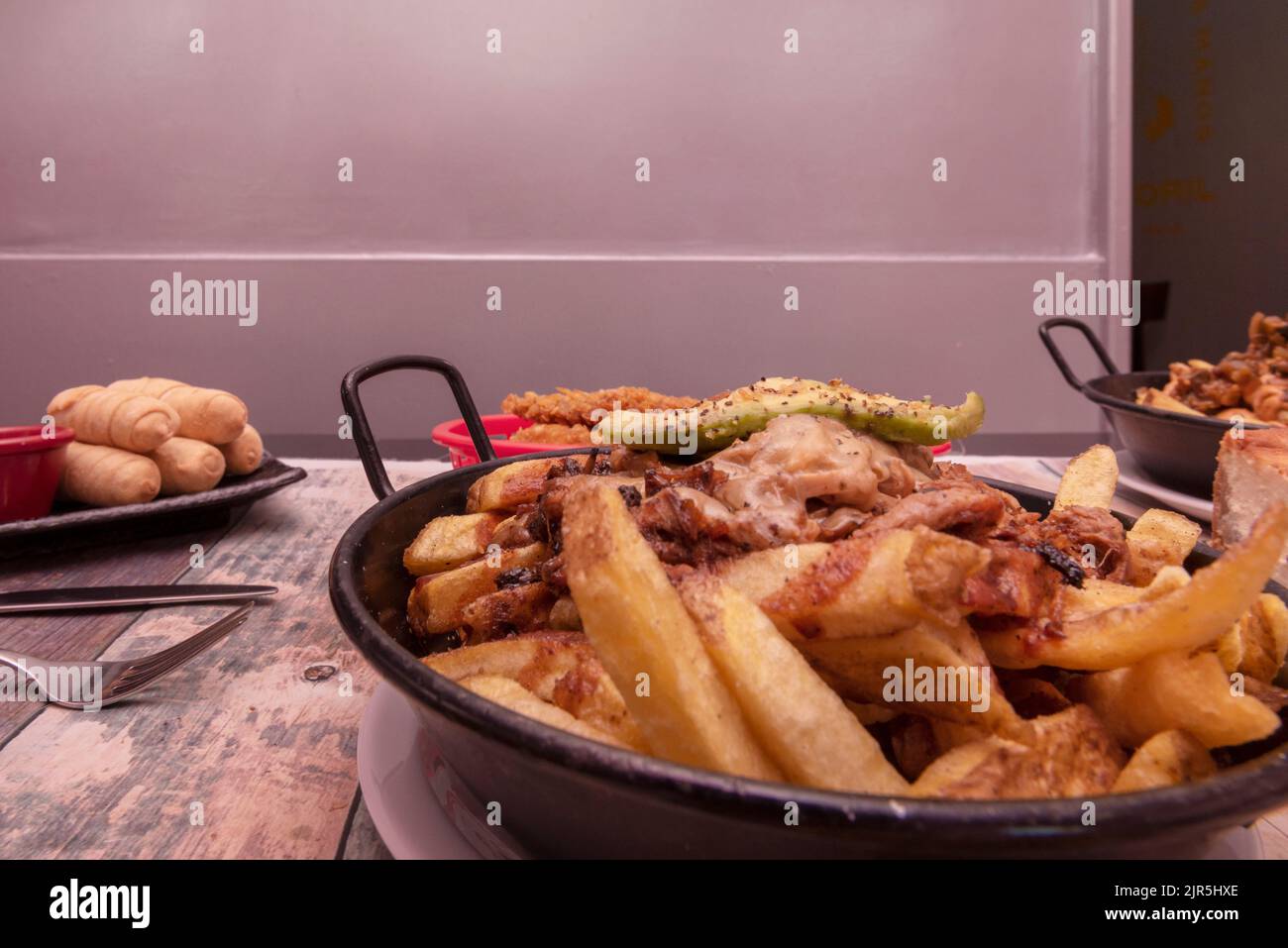 Fast food dishes prepared with fried potatoes with melted cheese, fried ...