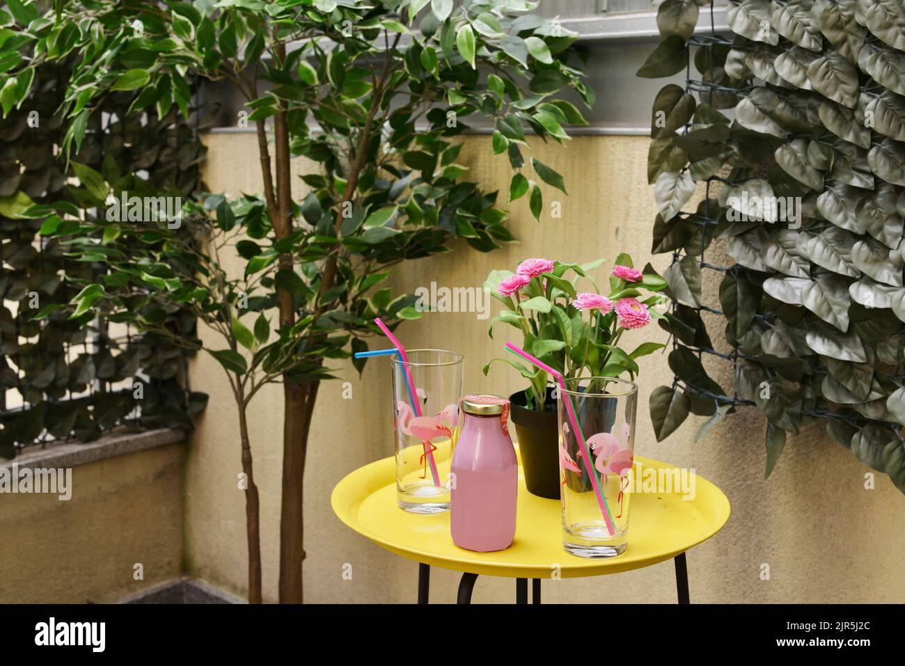 Corner of a terrace with artificial decorative plants, yellow metal ...