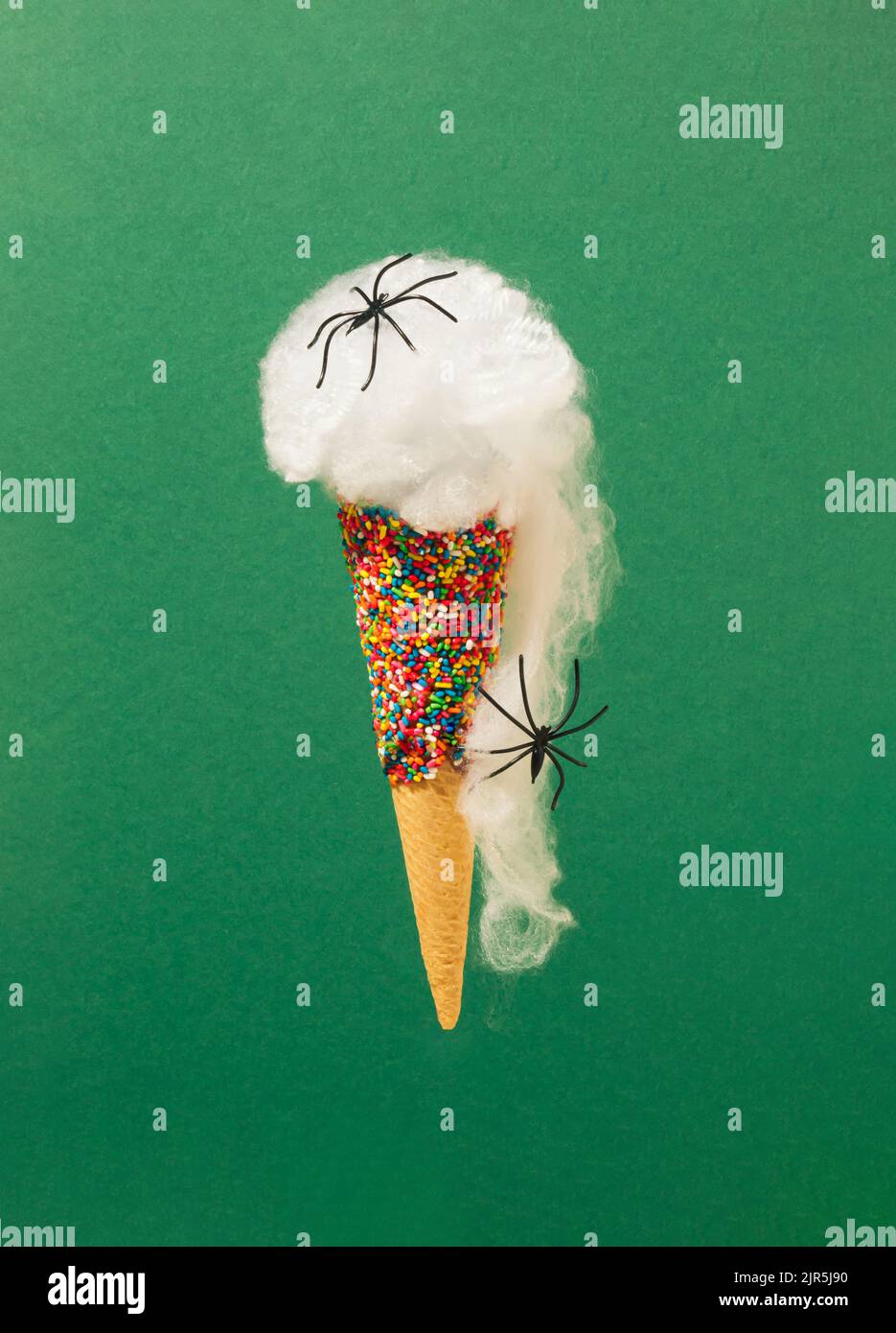 Ice cream cone with sprinkles, spider web and spiders on green ...