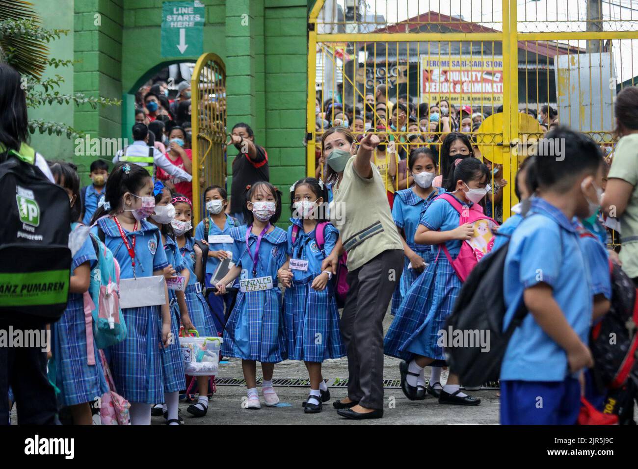 Manila, Philippines. 22nd Aug, 2022. Teachers assist students wearing ...