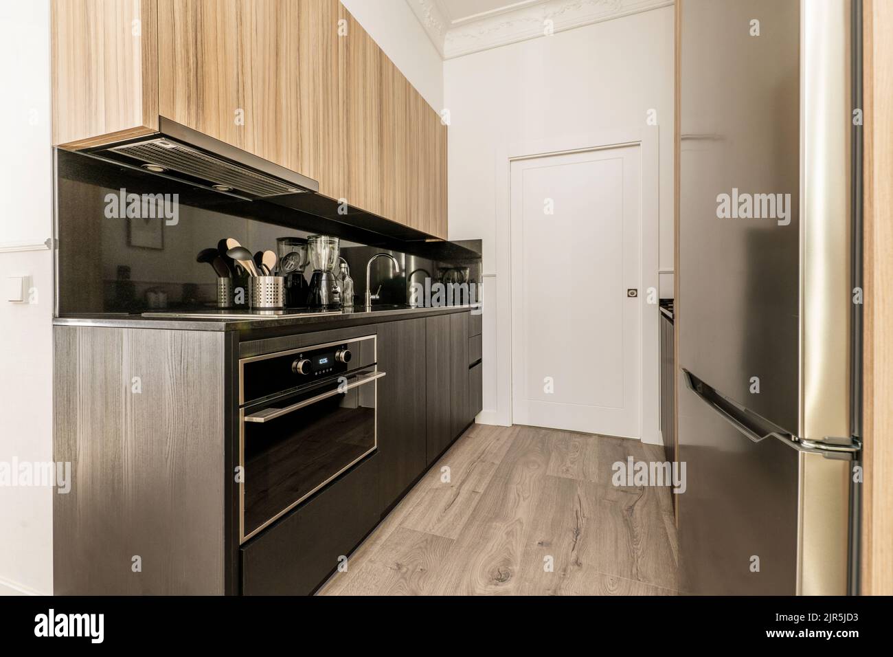 Kitchen with black base units, wooden upper units, black stone ...