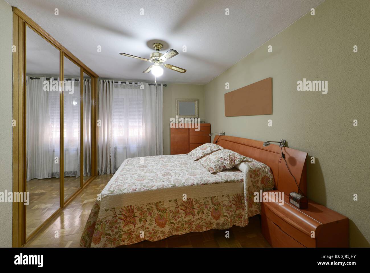 Bedroom with a double bed with a long cherry wood headboard that ...