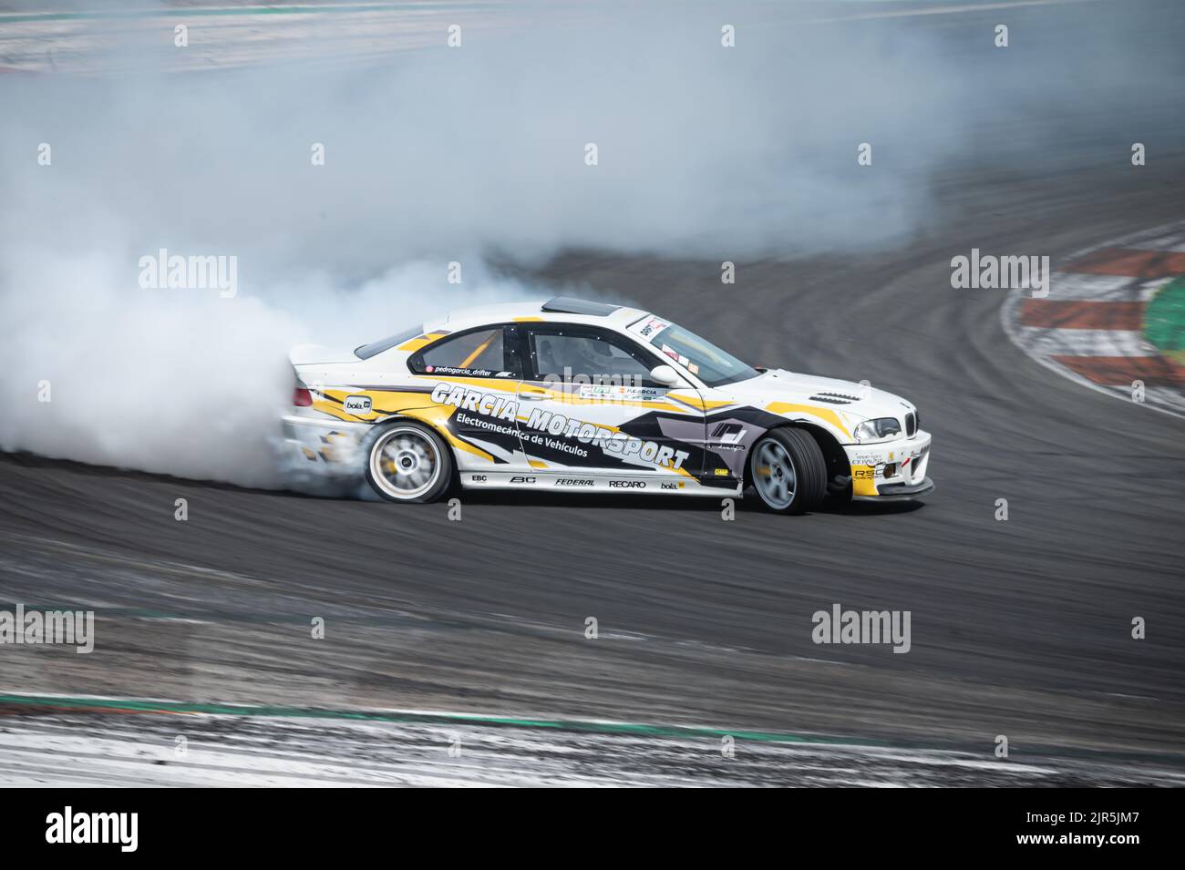 A white yellow BMW E36 producing smoke on a trail for a drift ...