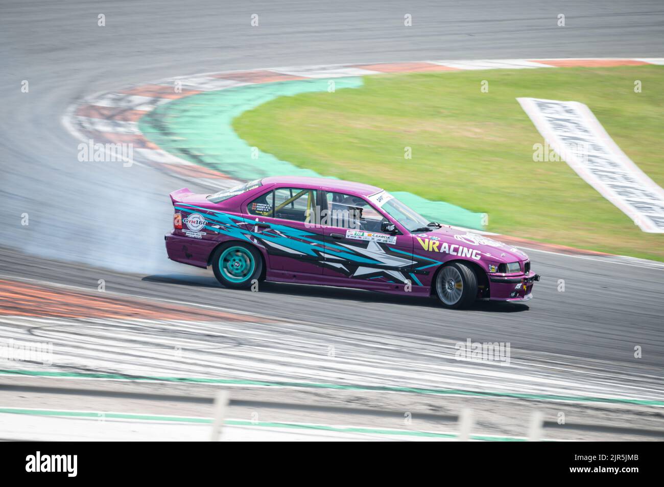 A purple BMW E36 with a star design producing smoke on a trail for a ...