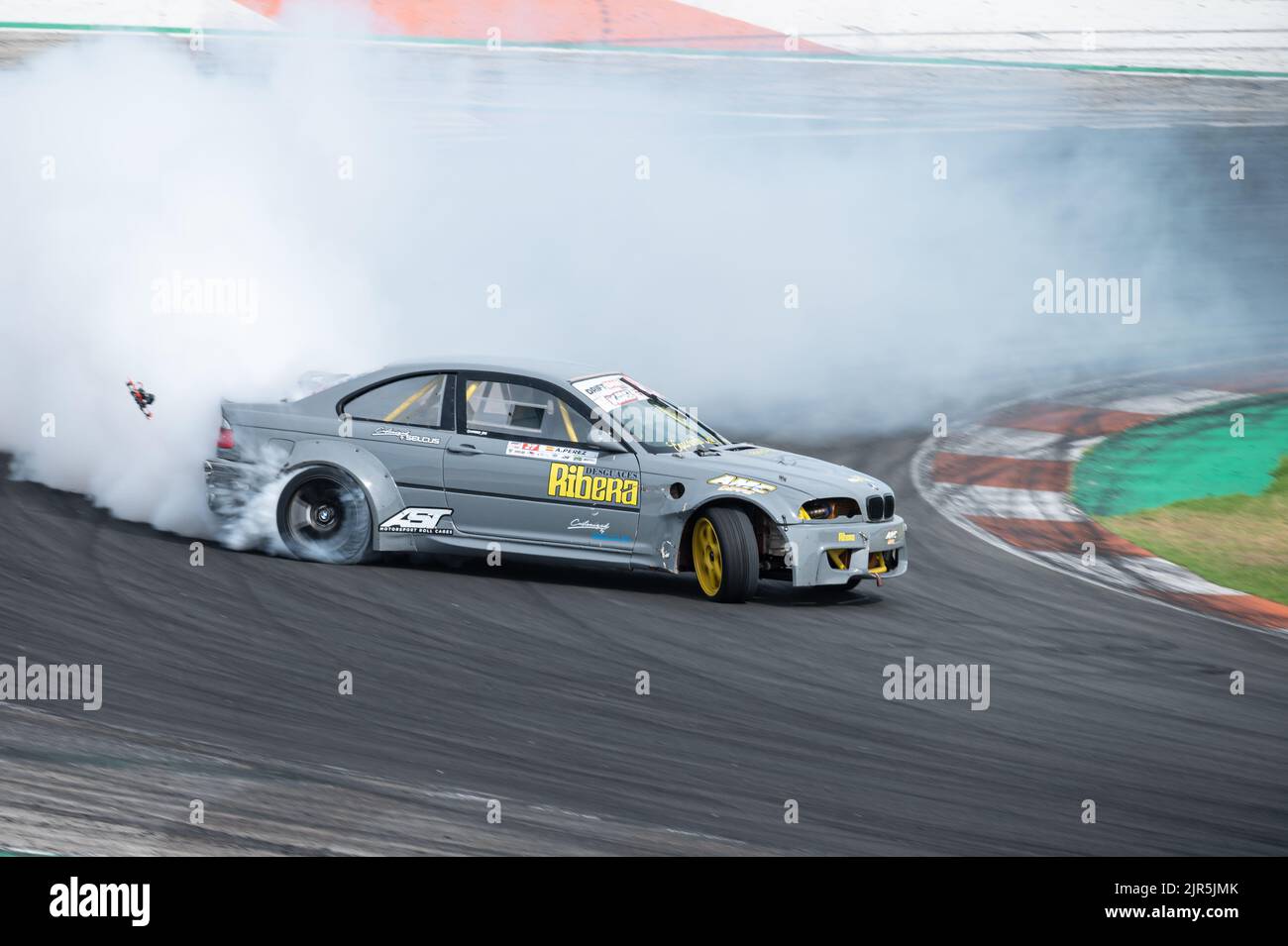 A gray BMW E46 producing smoke on a trail for a drift competition Stock ...