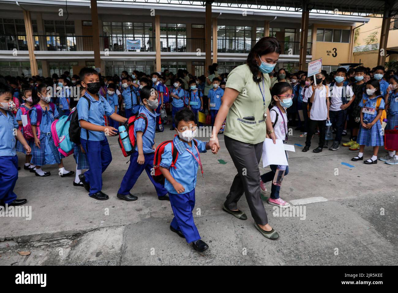 Manila, Philippines. 22nd Aug, 2022. Teachers assist students wearing ...