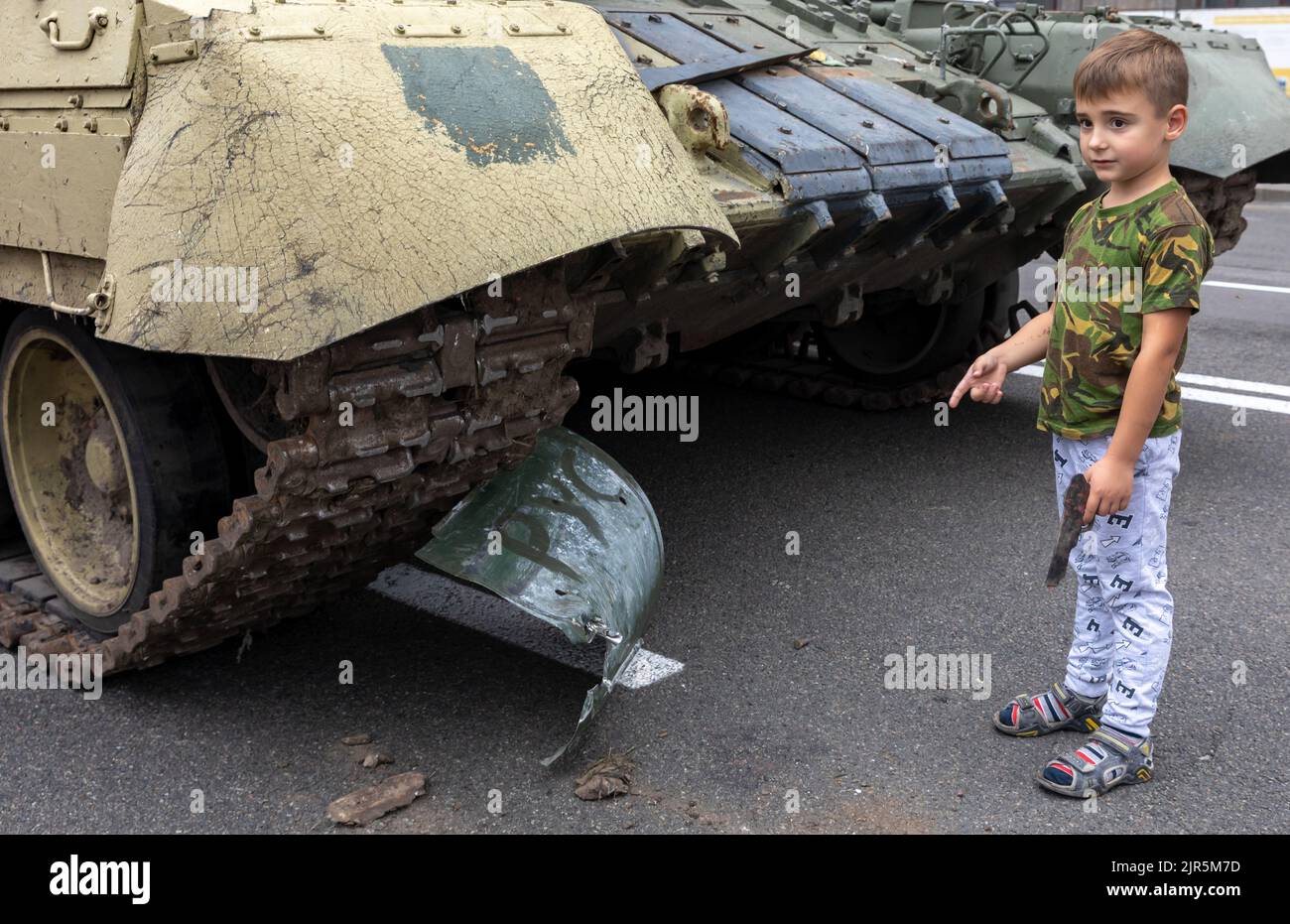 KYIV, UKRAINE - Aug. 20, 2022: Boy with toy gun near russian armoured ...