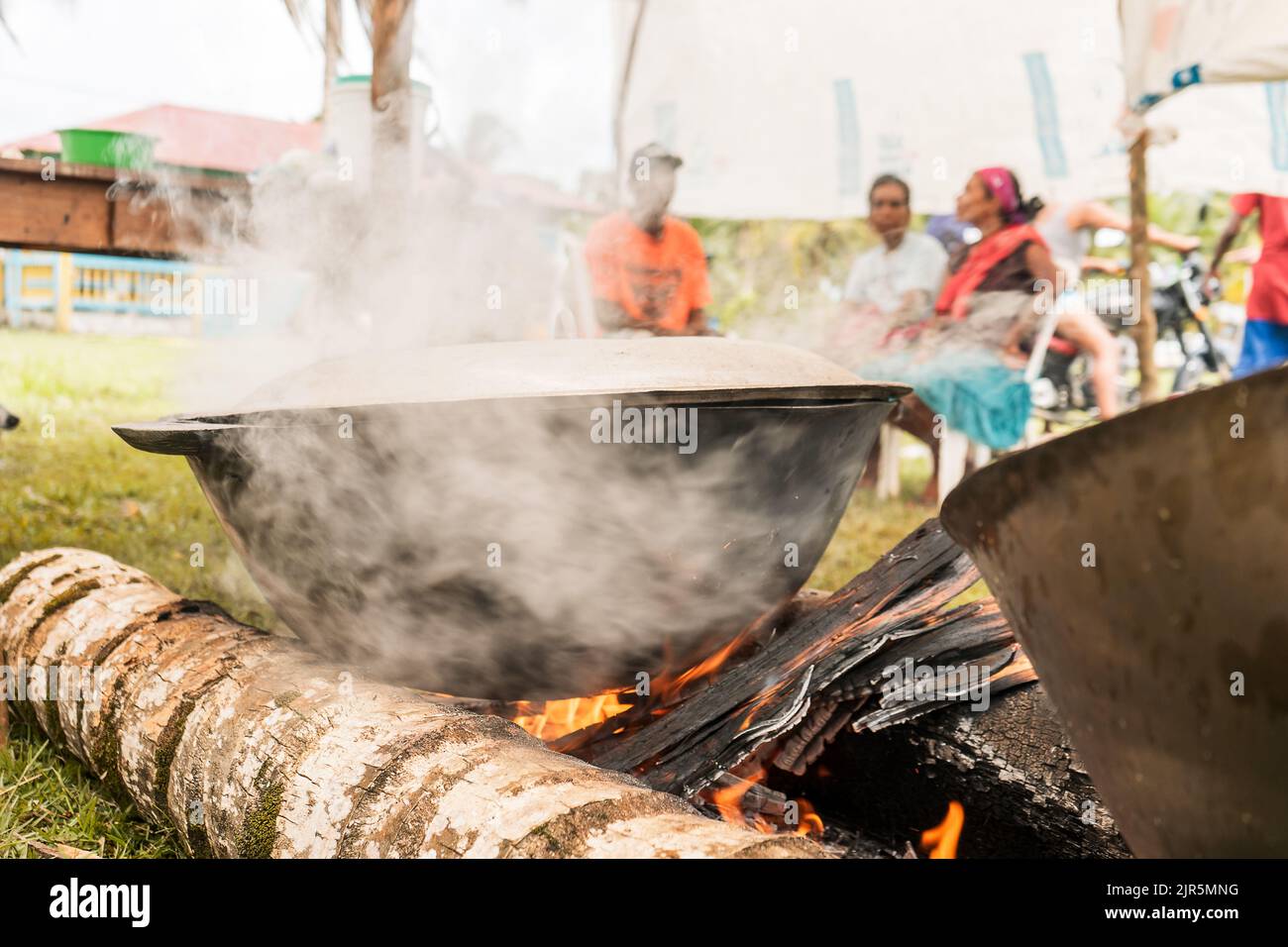 Unrecognizable indigenous people preparing a broth over a pot on a ...