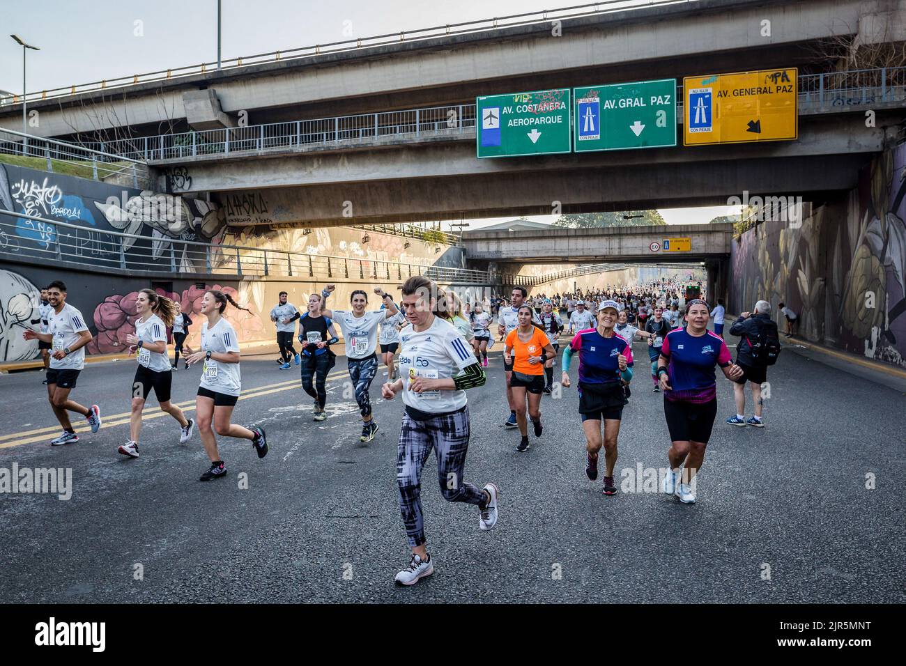 Buenos Aires, Argentina - 21 Aug 2022, A group of runners pass under the President Illia highway ...