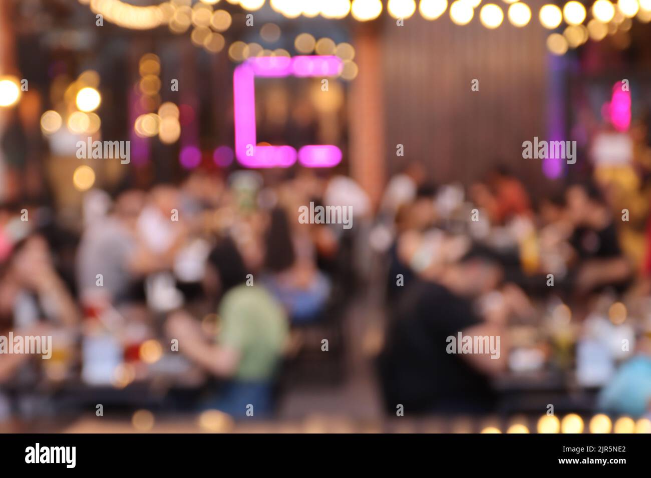 blurred image at the restaurant night time, many people in the ...