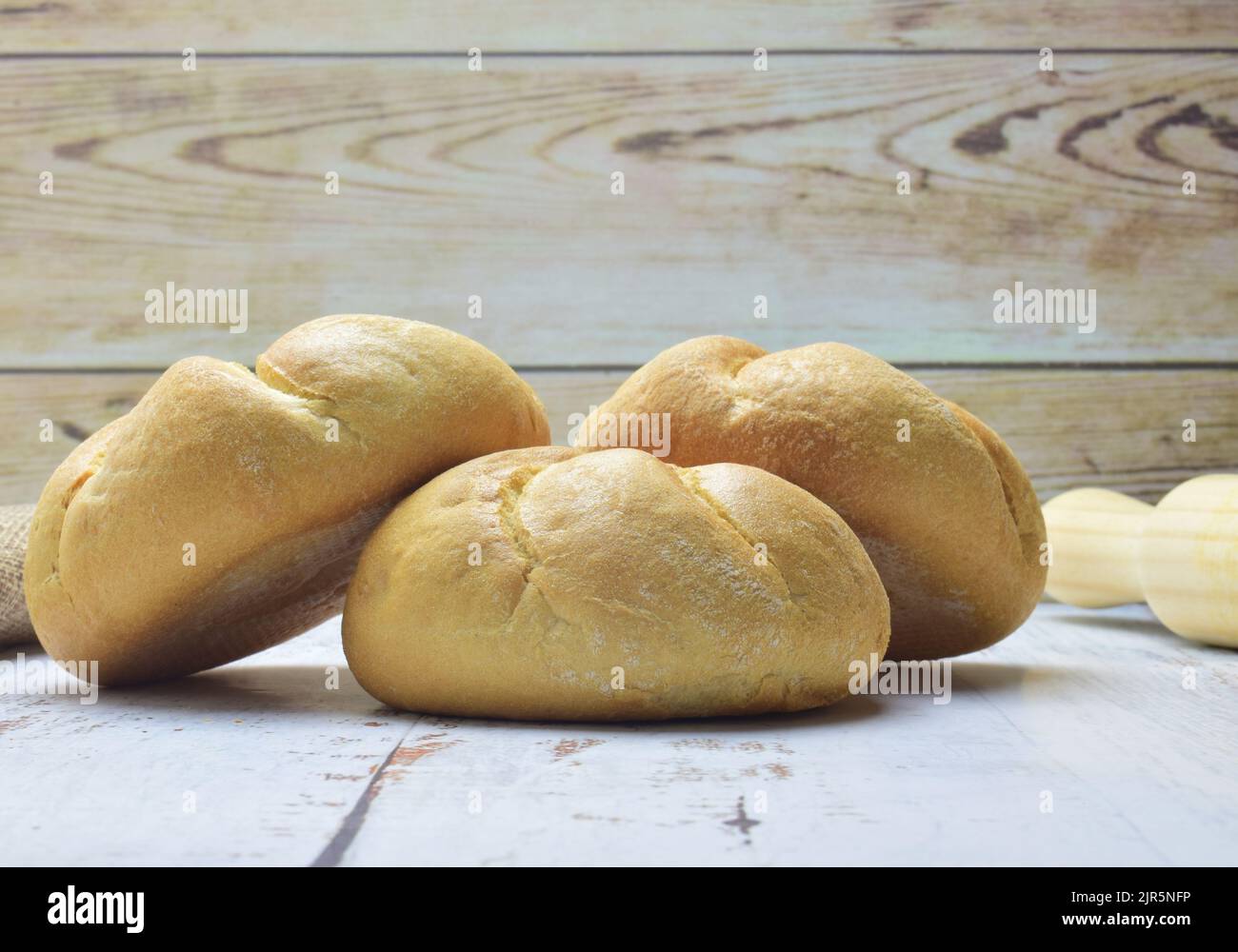 Small round loaves on a light-colored rustic table Stock Photo - Alamy