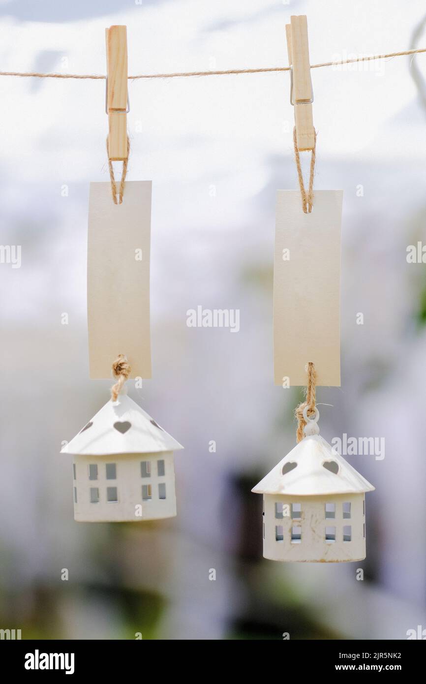 A vertical closeup of two decorative mini house models with blank ...