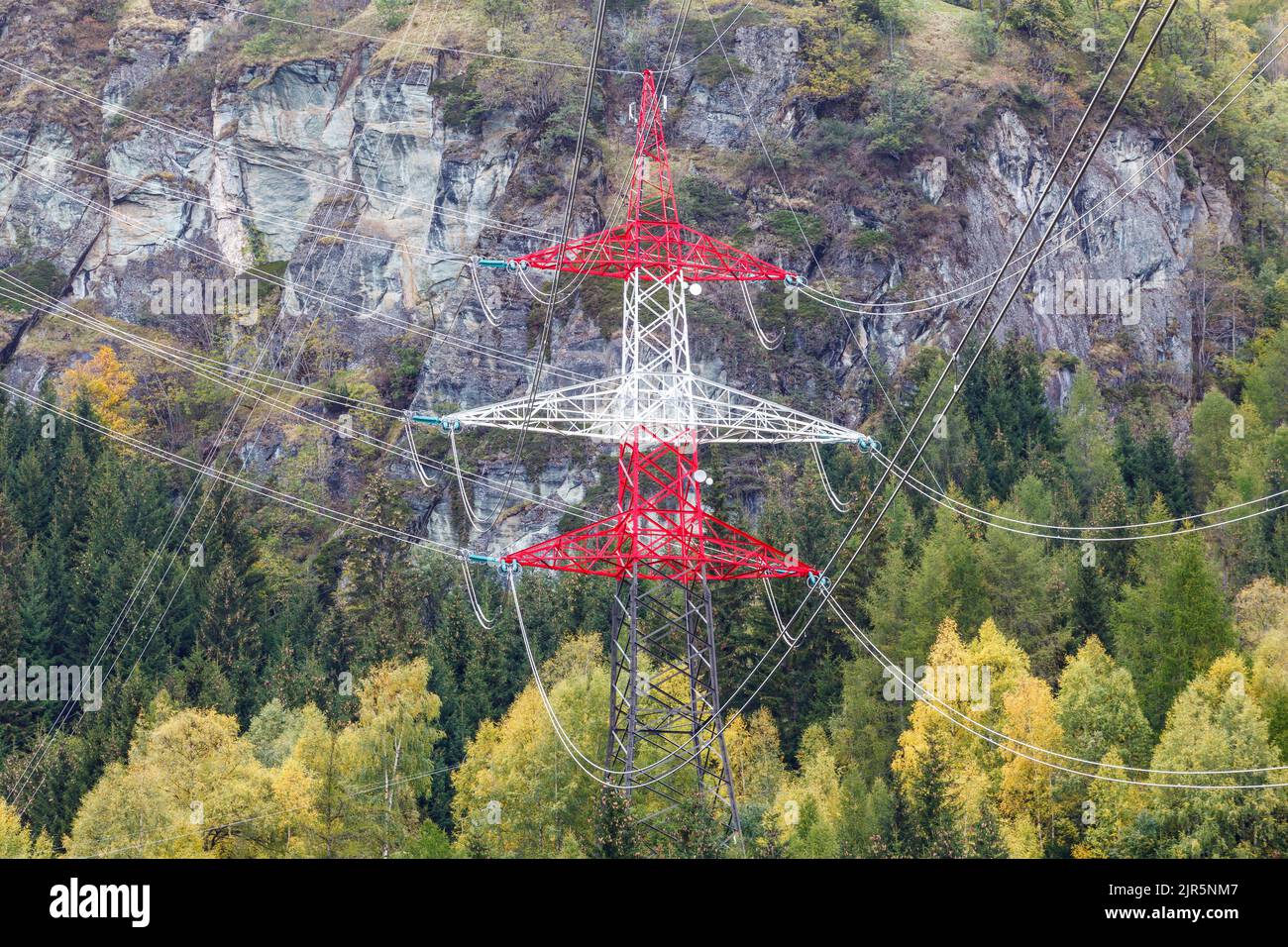 Power line by a rock wall and autumn colors in the forest Stock Photo ...