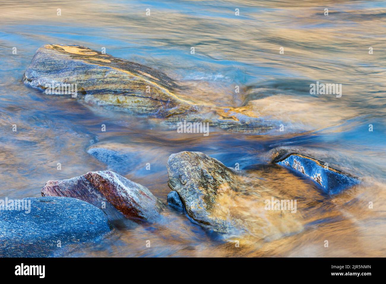 Rocks in a stream with flowing water Stock Photo - Alamy