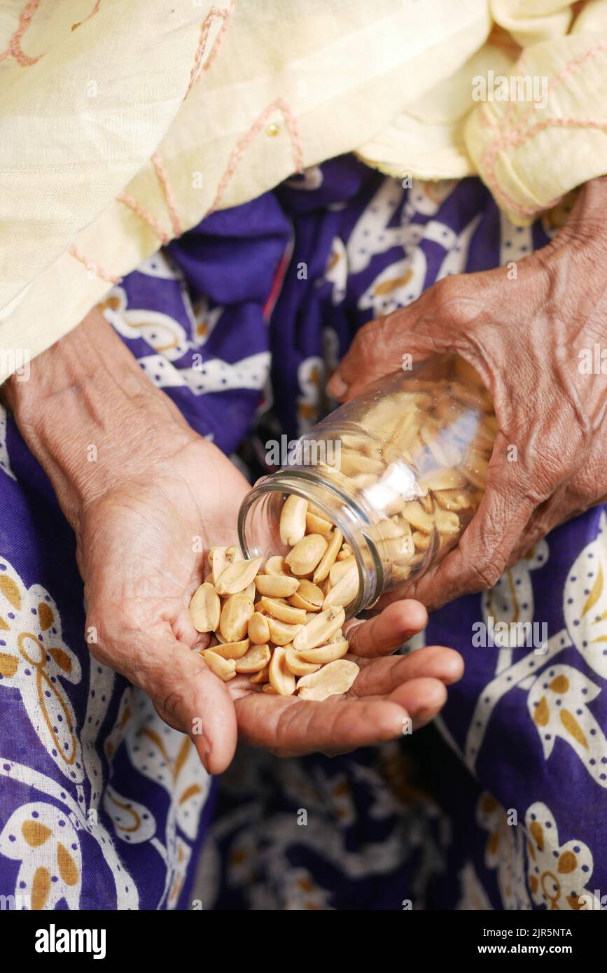 Senior women eating pouring peanuts hi-res stock photography and images ...