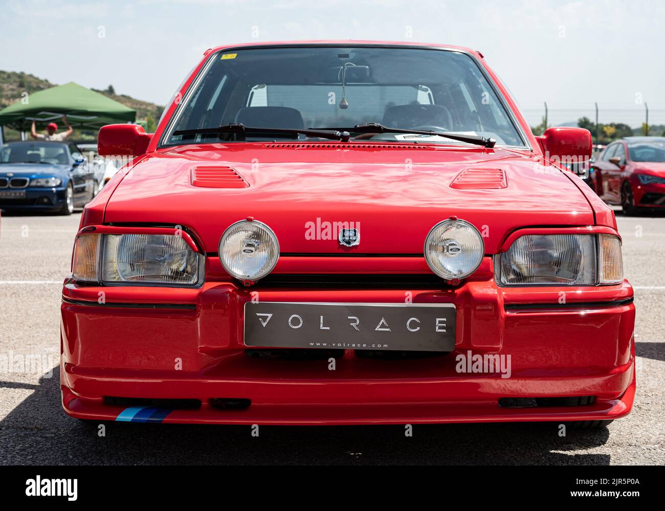 A red classic red fourth generation Ford Escort parked on a street ...