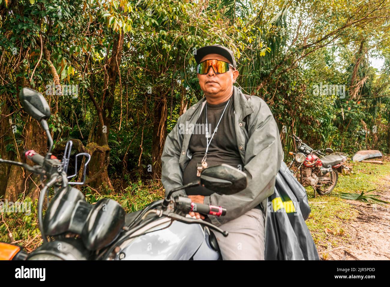 Indigenous man riding a motorbike in a Caribbean community of Nicaragua ...