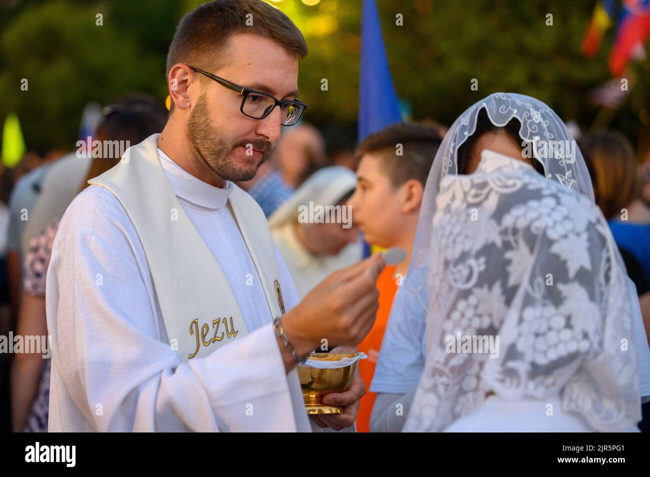 A priest giving the Holy Communion to the faithful Stock Photo - Alamy