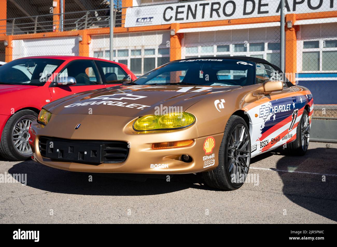 A 5th generation Chevrolet Camaro in gold color and an American flag ...