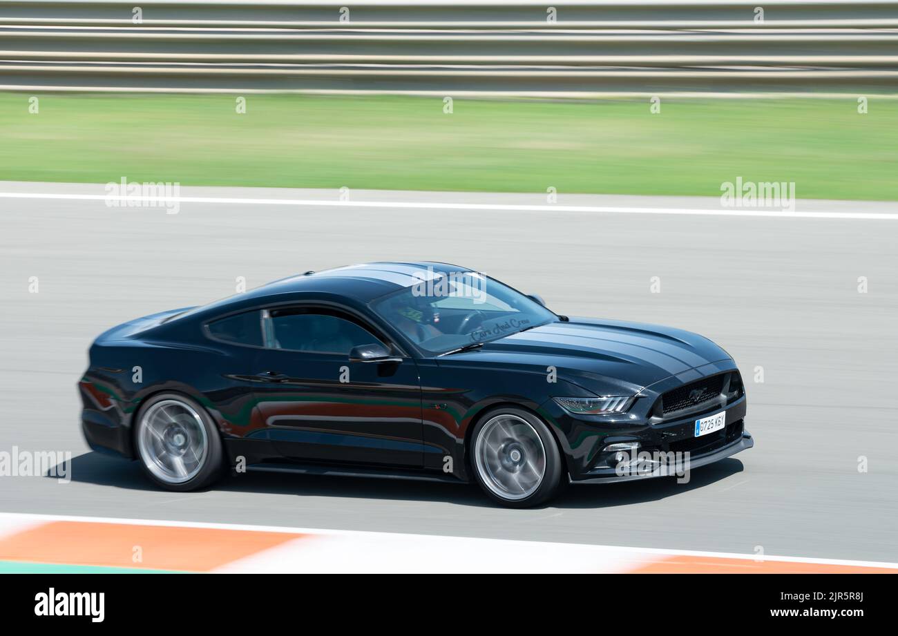 A black stunning Ford Mustang racing around on a competition track ...