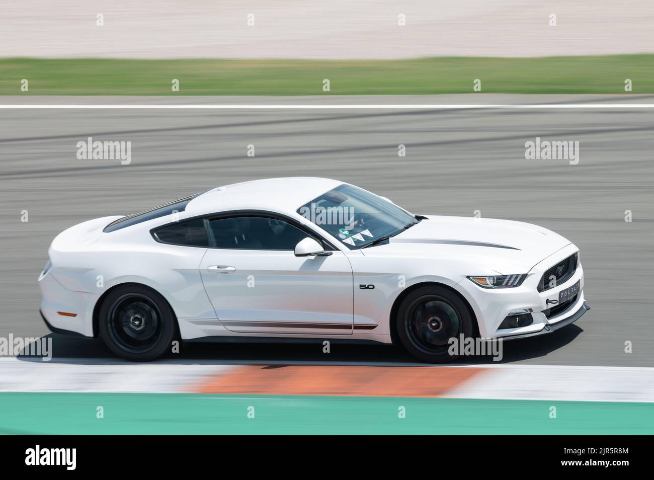 A stunning white Ford Mustang racing around on a competition track ...