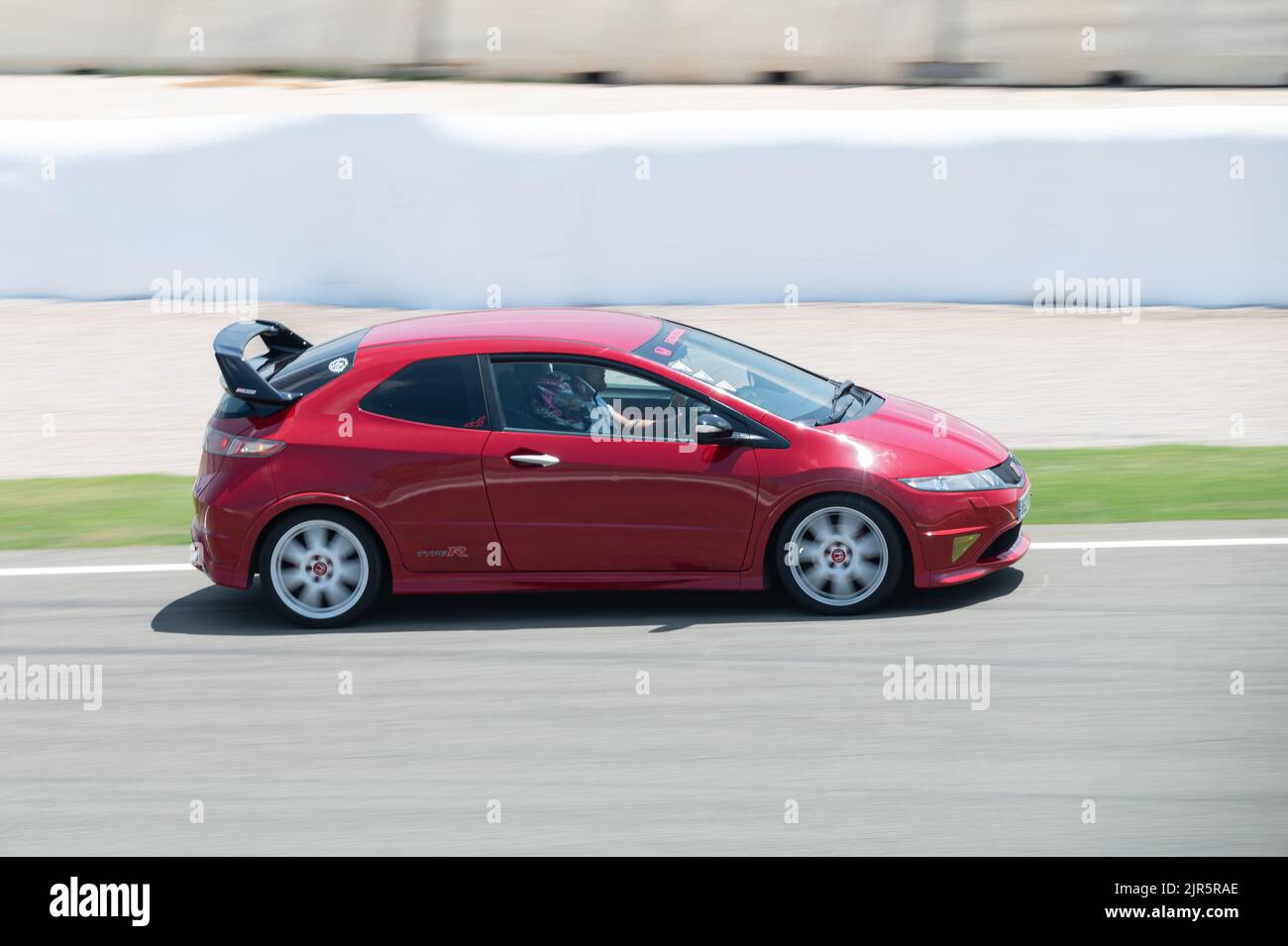 A red 8th generation Honda Civic FN Japanese sports car racing around ...