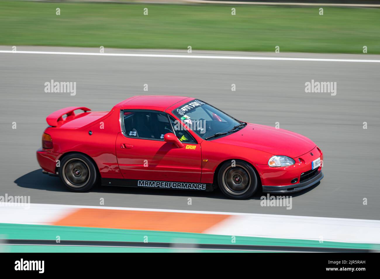 A red Japanese Honda CR-X Del Sol sports car racing around on a ...