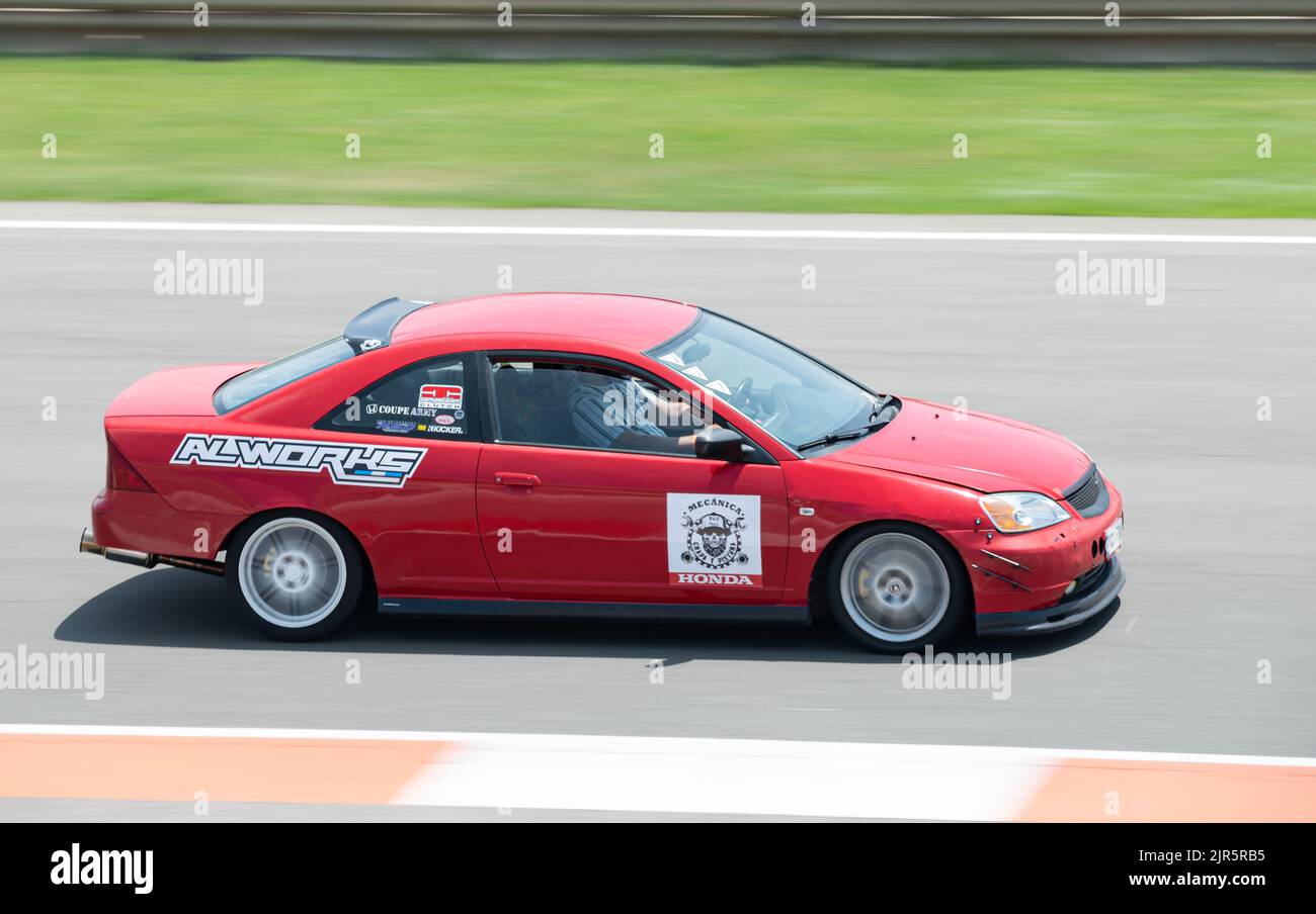 A red seventh generation Honda Civic sports car racing around on a ...