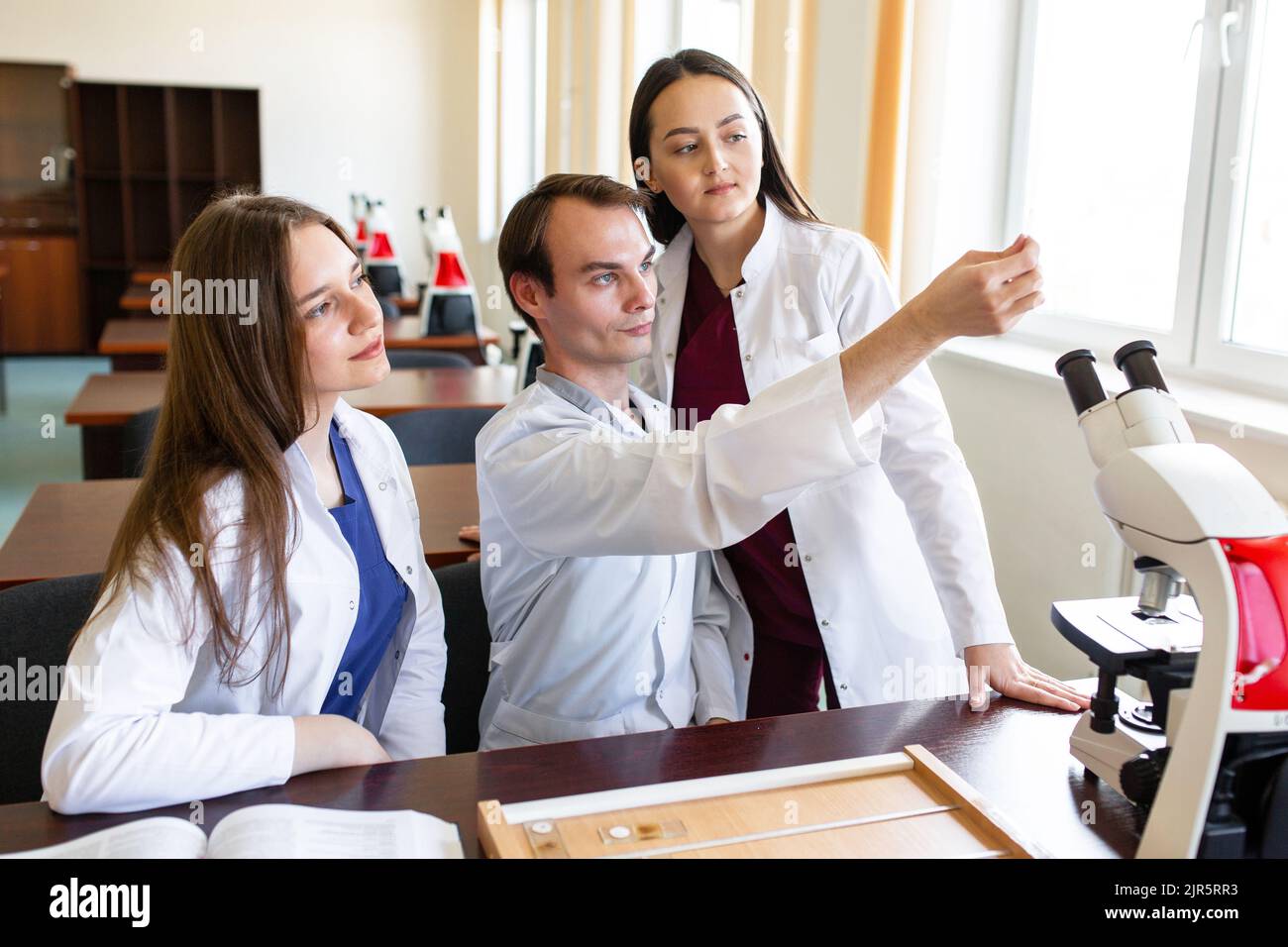 High School Students Looking Through Microscope In Biology Class. Young ...