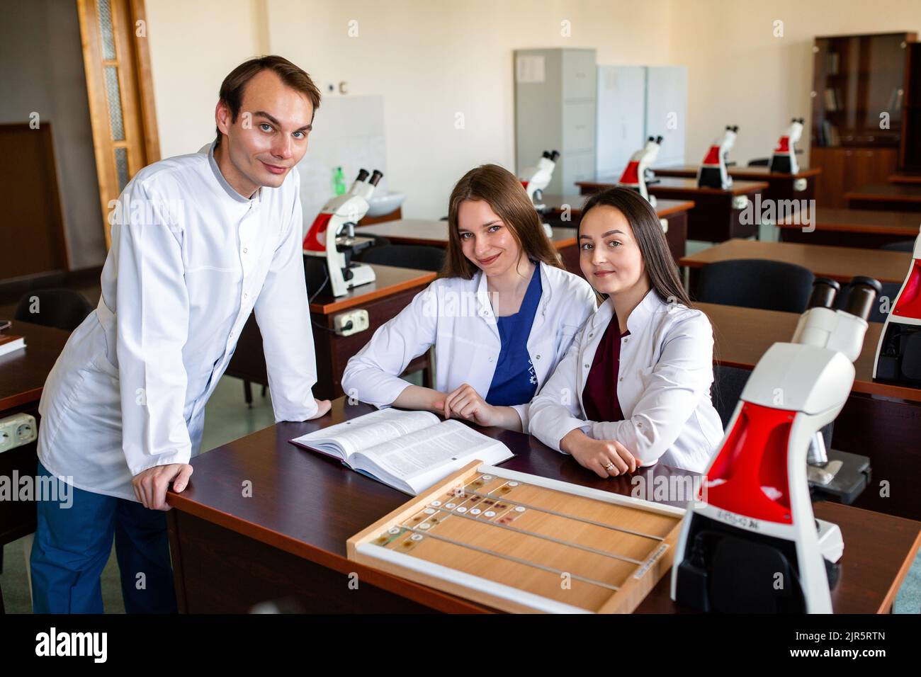 High School Students Looking Through Microscope In Biology Class. Young ...