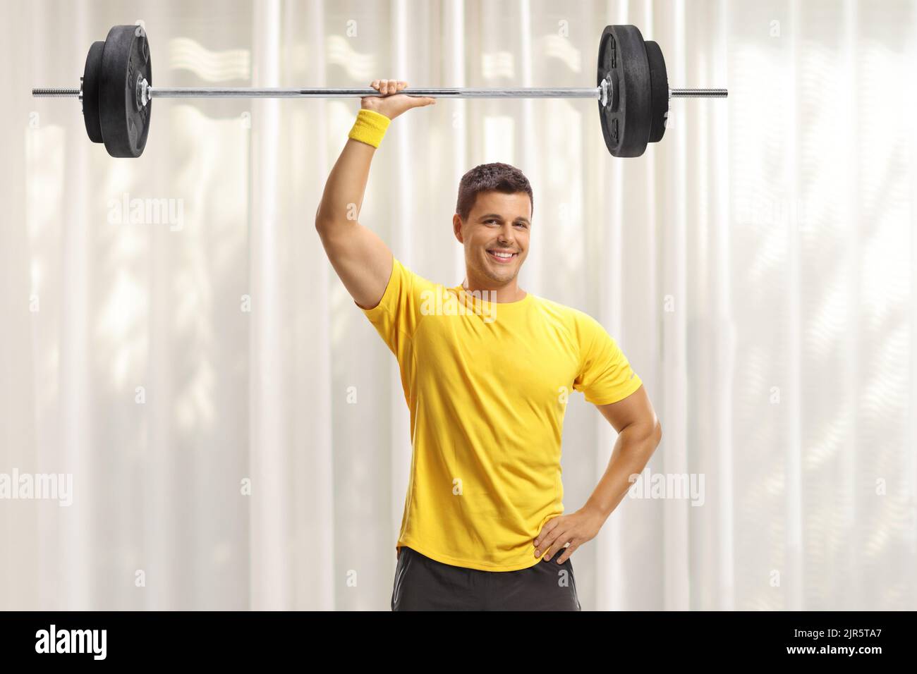 Strong fit man lifting weigths and smiling at camera Stock Photo - Alamy