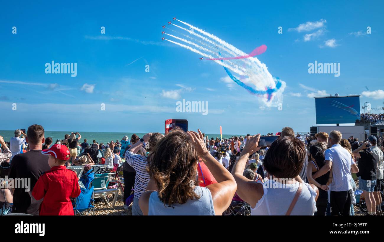 People watch the RAF Red Arrows aerobatic display team from the beach ...
