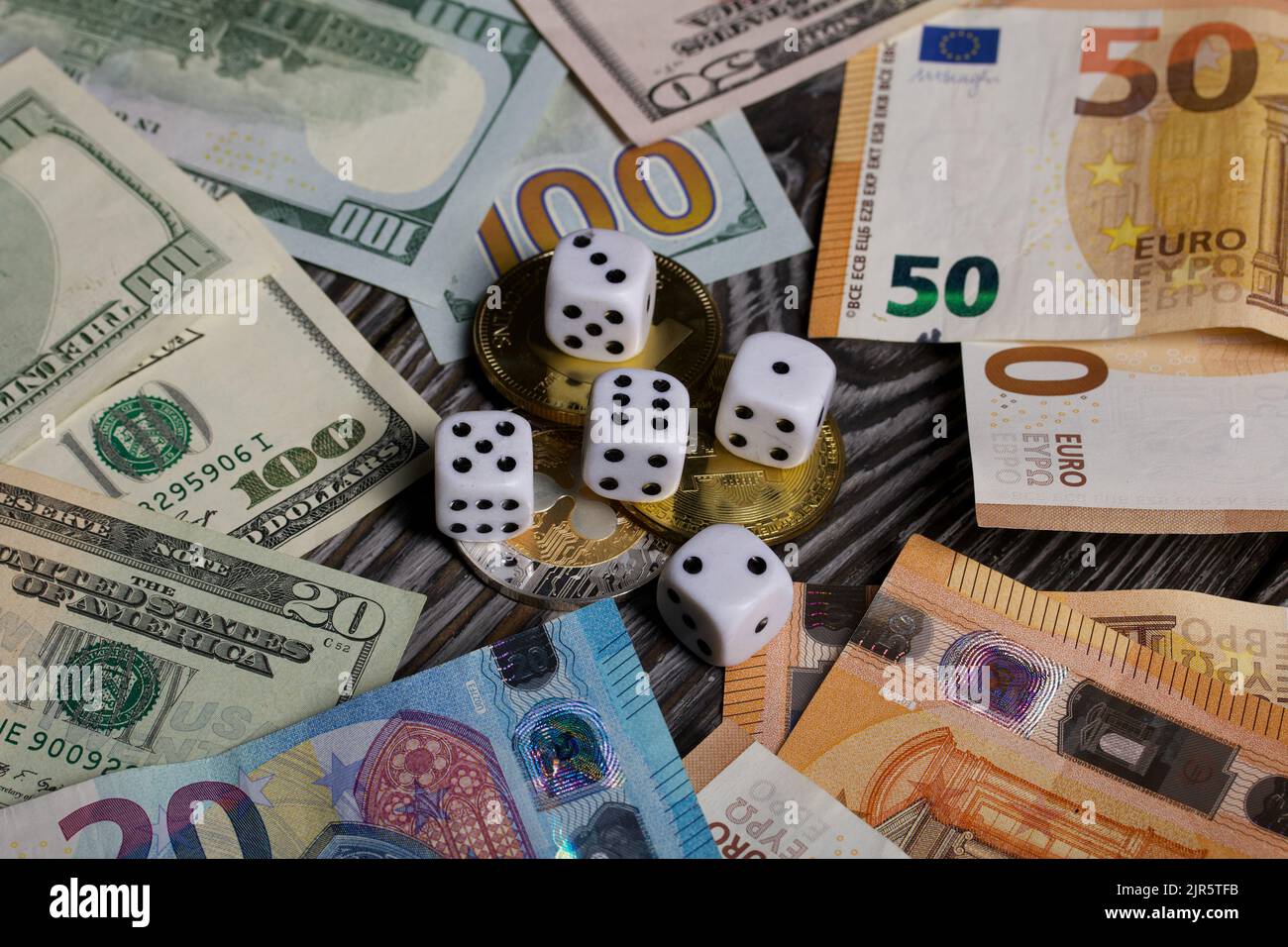 Dice among dollar and euro banknotes. Cryptocurrency coins ...