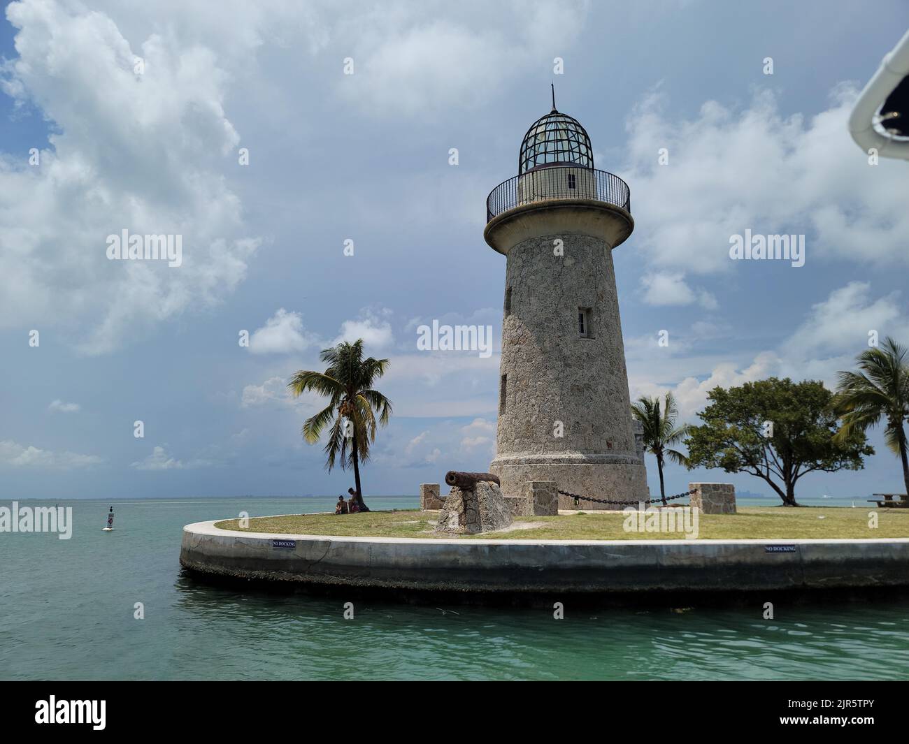 The Boca Chita lighthouse by the water under the cloudy sky in Florida ...