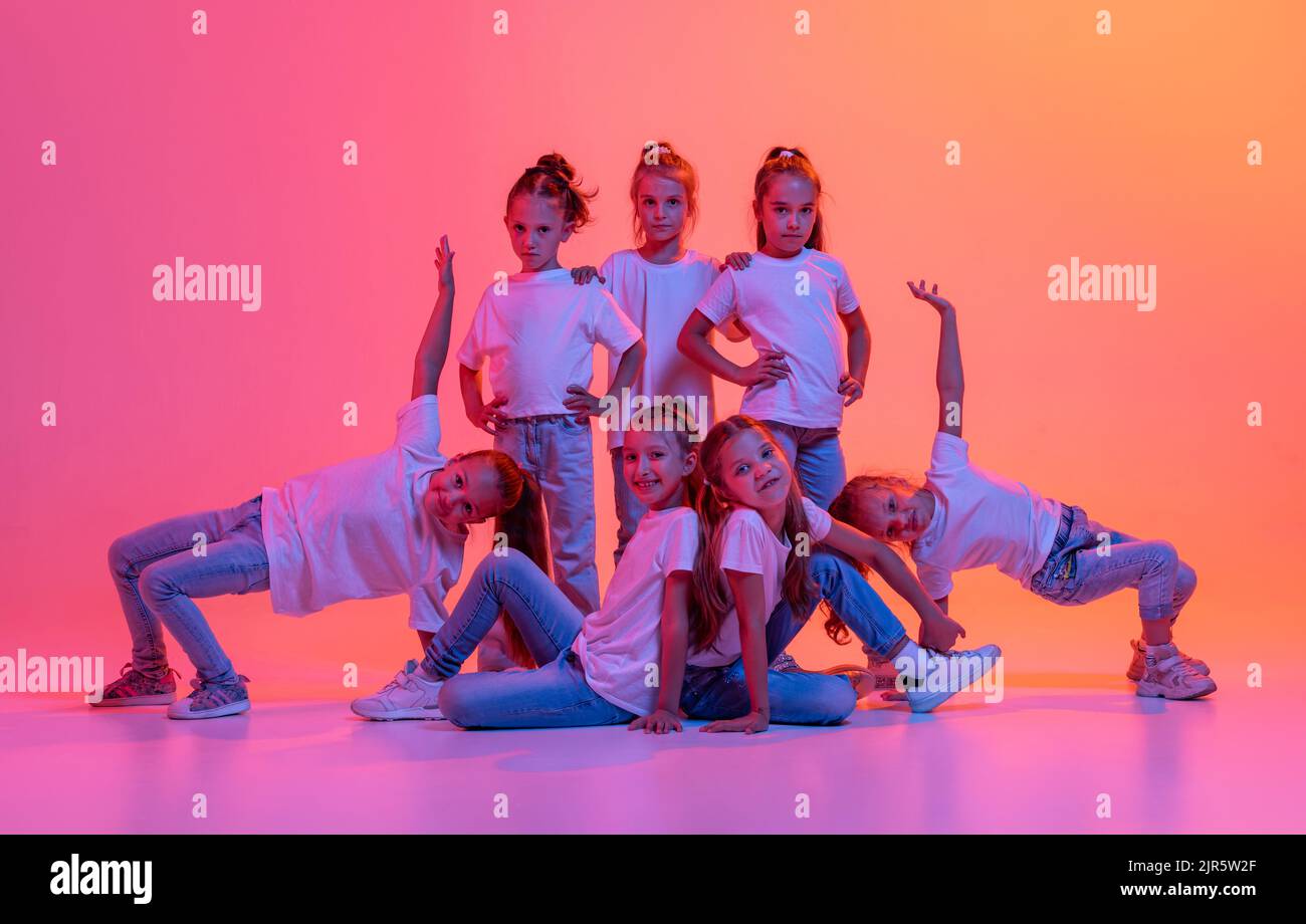 Happy kids, school age girls in white t-shirts and jeans dancing in ...