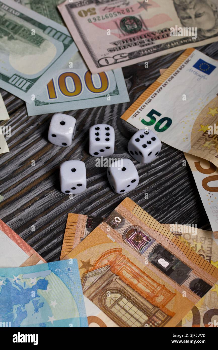 Dice among dollar and euro banknotes. Multicurrency savings. Risk while ...