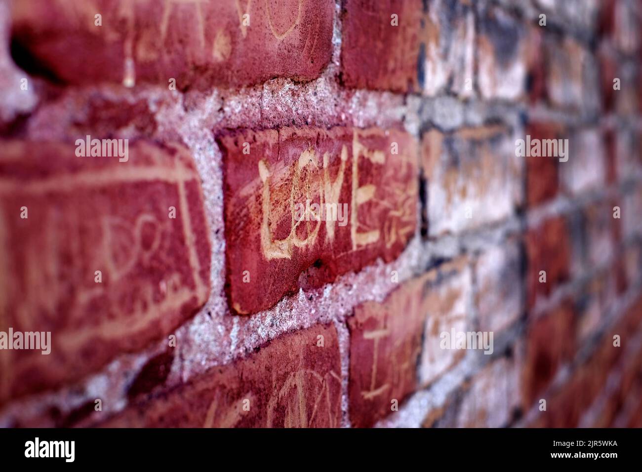 Love and symbol of affection scratched written on old brick wall Stock ...