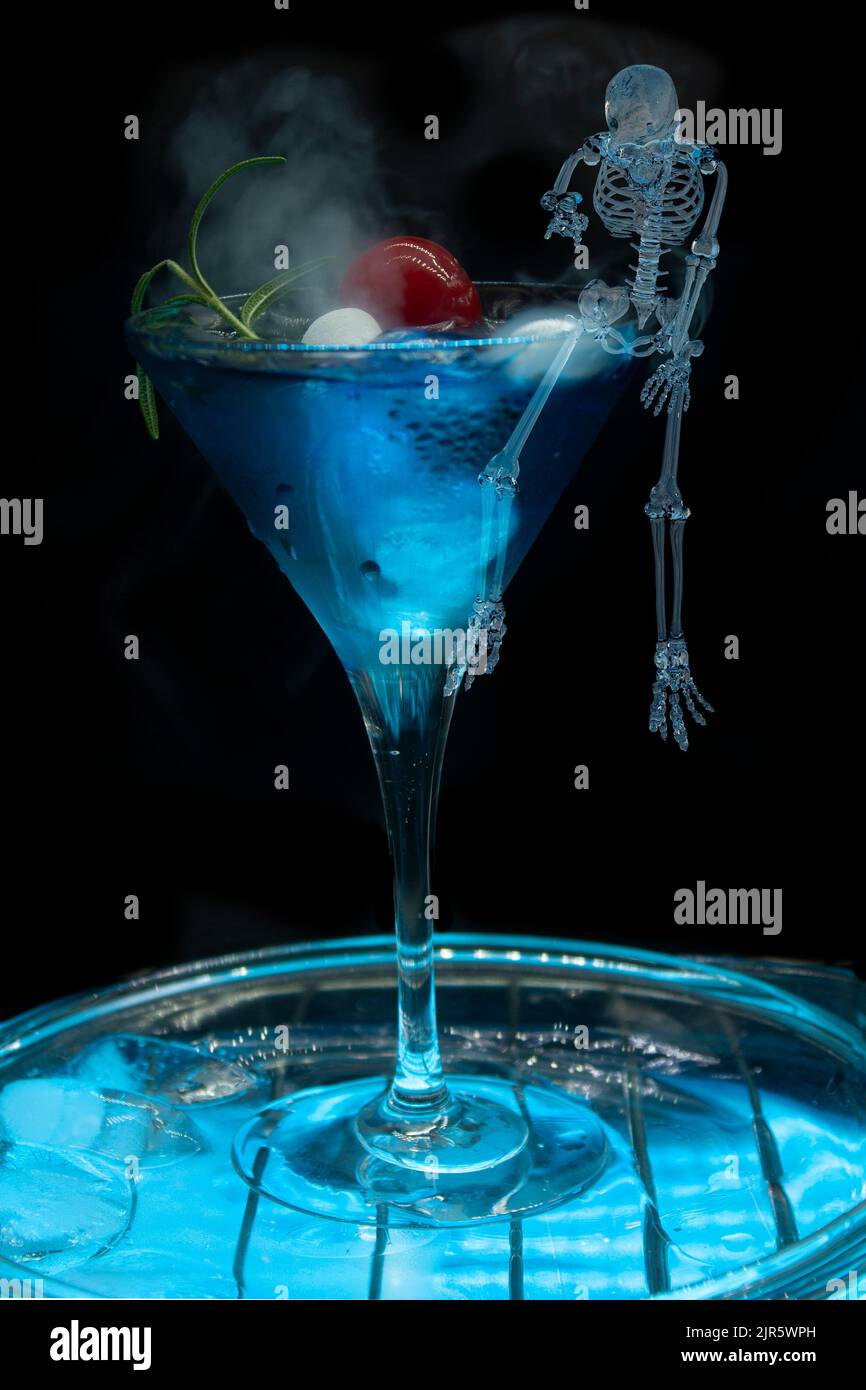 Cup with drink to celebrate Halloween with ice human skeleton sitting ...