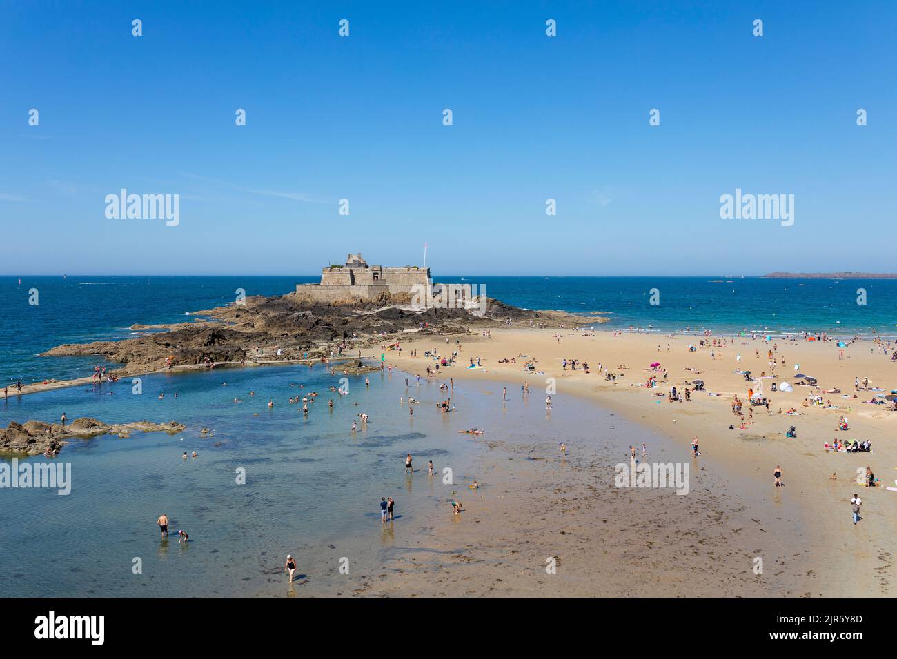 Swimming and sunbathing people at the beach of Saint Malo, fortress in ...