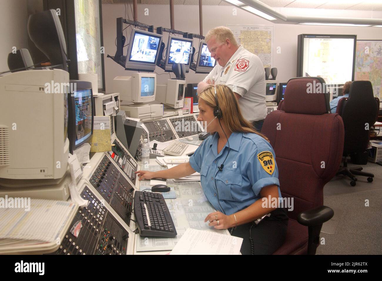A Brookfield City, Wisconsin fire chief looks on as a female dispatcher ...