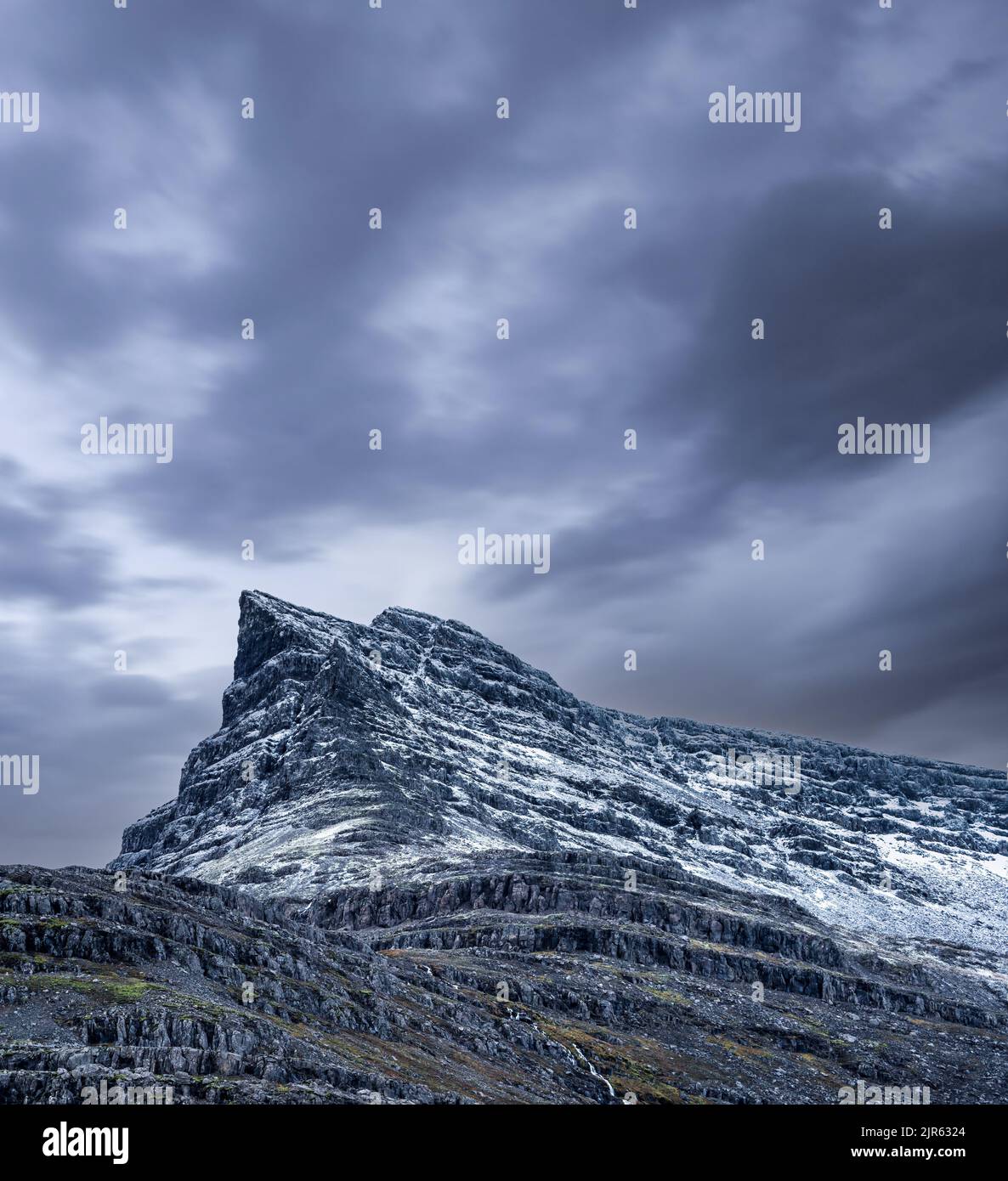 Sharp mountain peak under cloudy sky on winter Stock Photo - Alamy