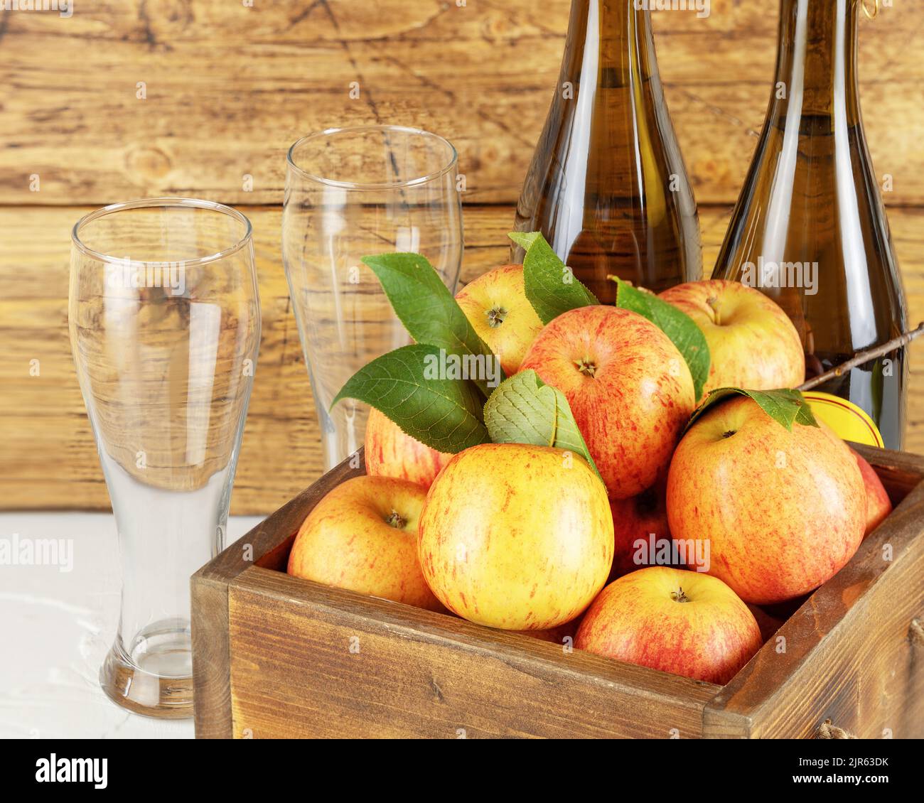 Apple cider drink or fermented fruit drink. Bottles with cider, glasses ...