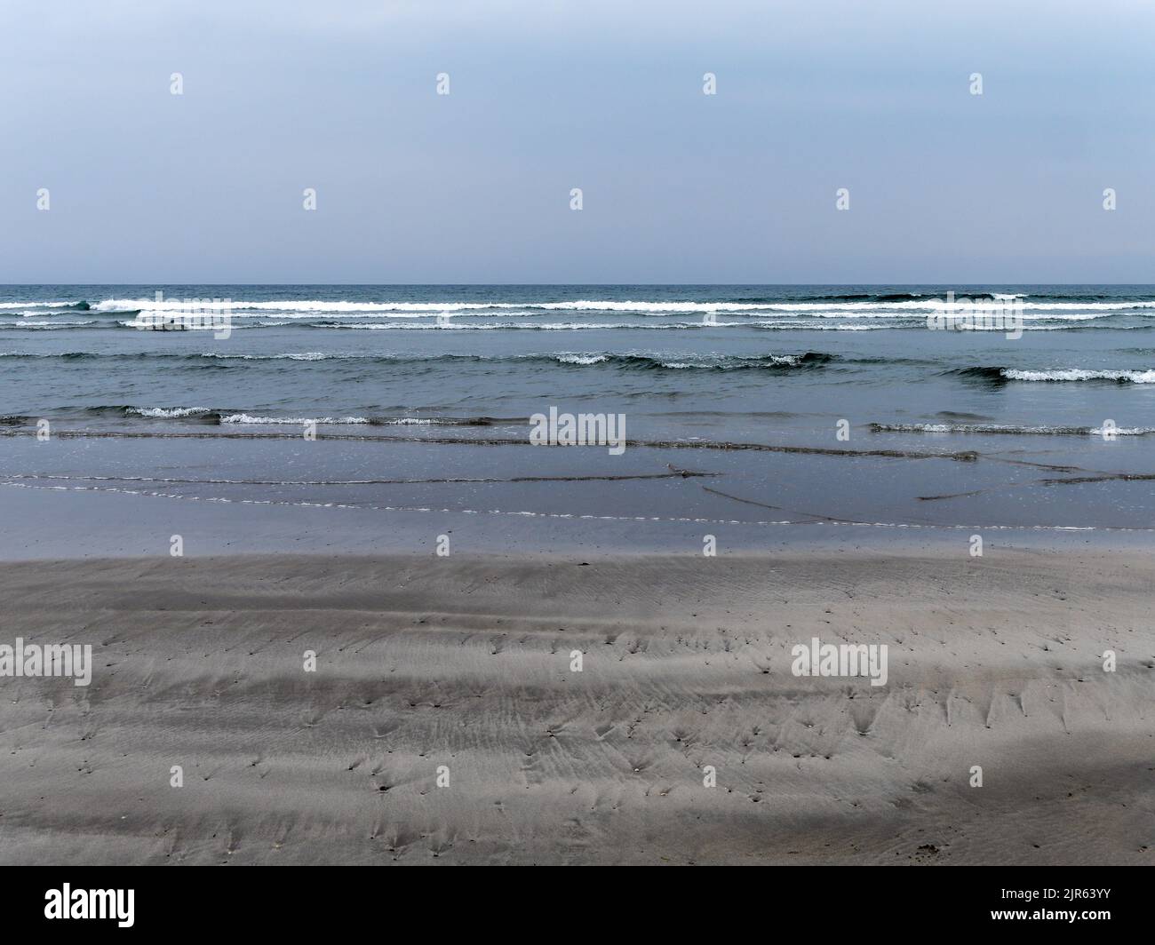 The shore of the Celtic Sea at low tide. Wet sandy beach on a cool day ...