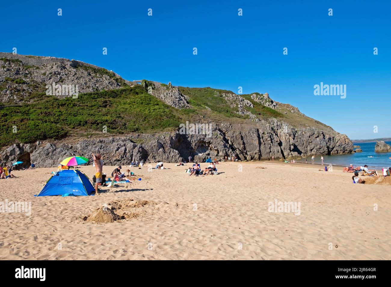 People holiday makers bathers relaxing on the sandy beach in summer at ...