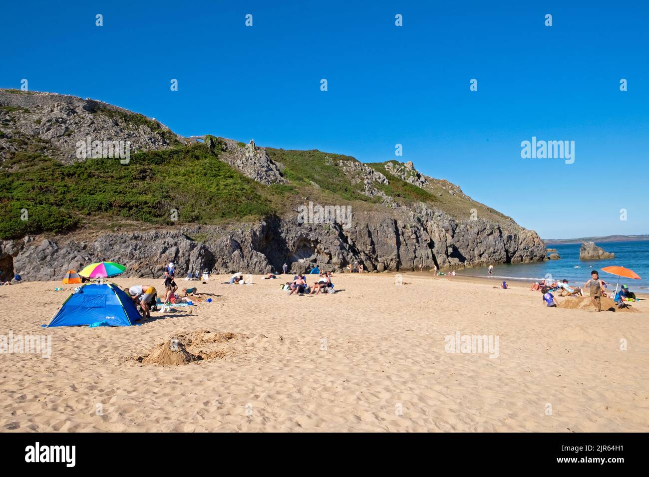 People holiday makers bathers relaxing on the sandy beach in summer at ...