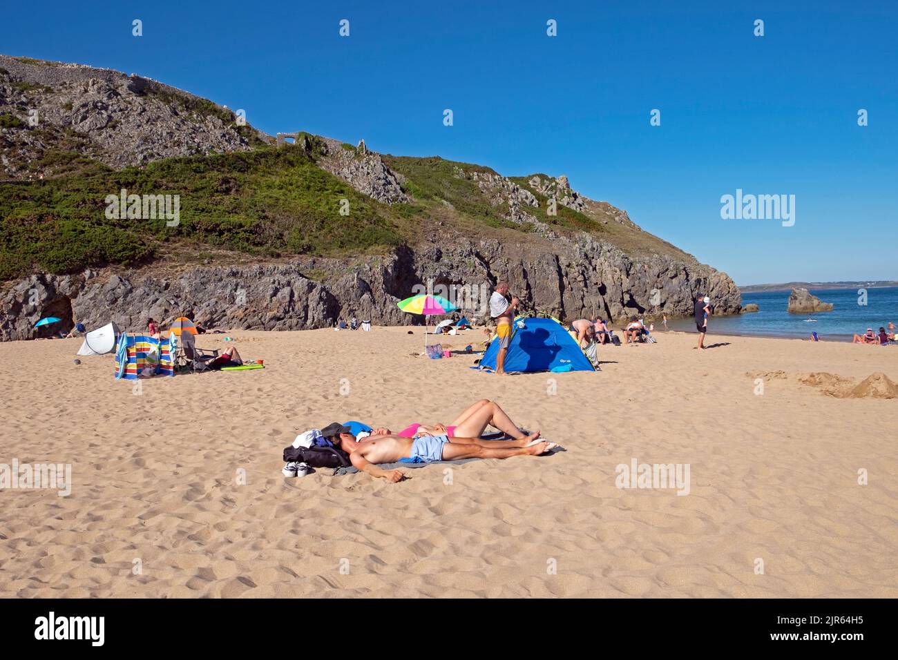 People holidaymakers couple lying relaxing on the sandy beach in summer ...