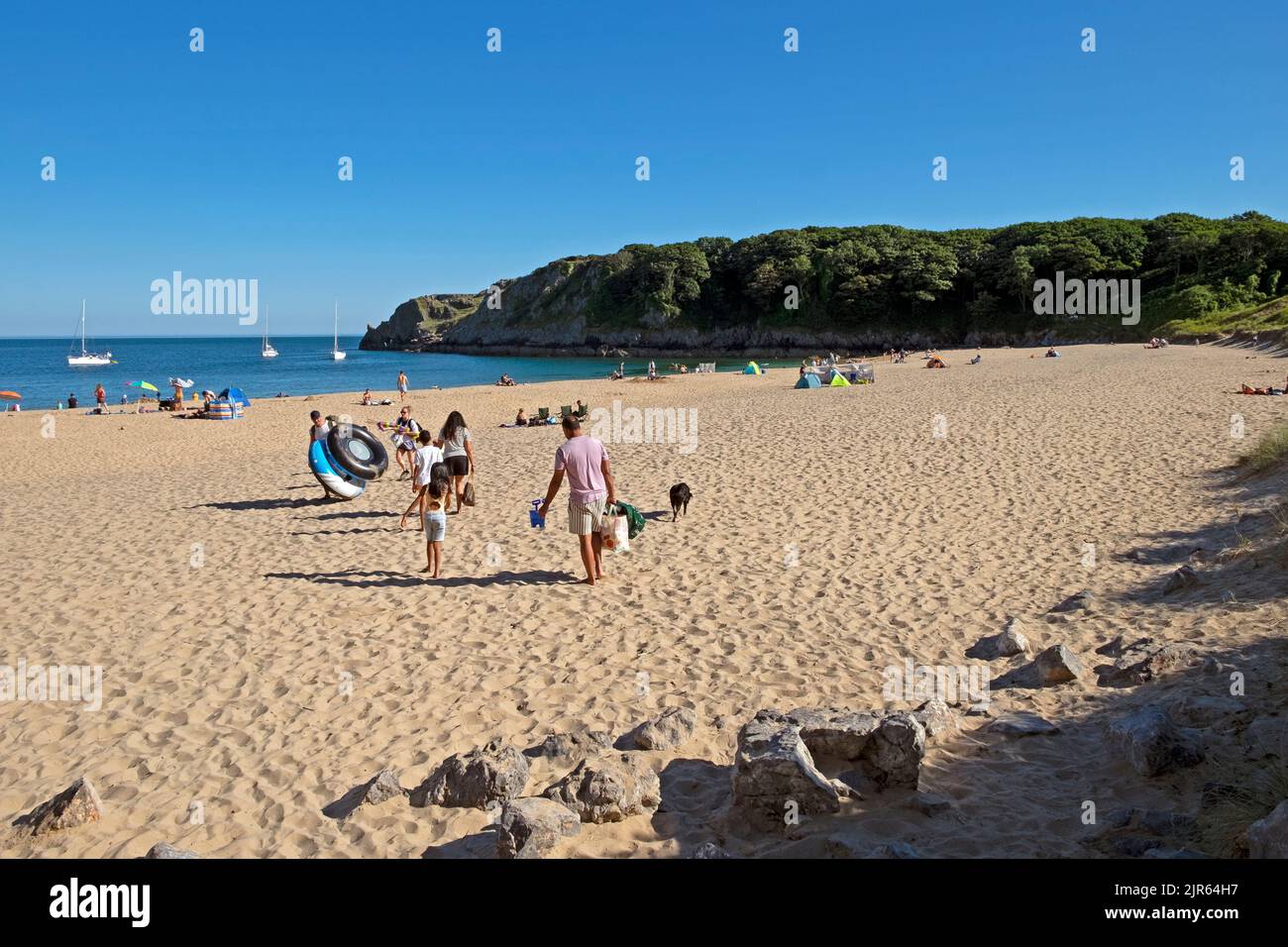 People family holidaymakers walking relaxing on the sandy beach in ...